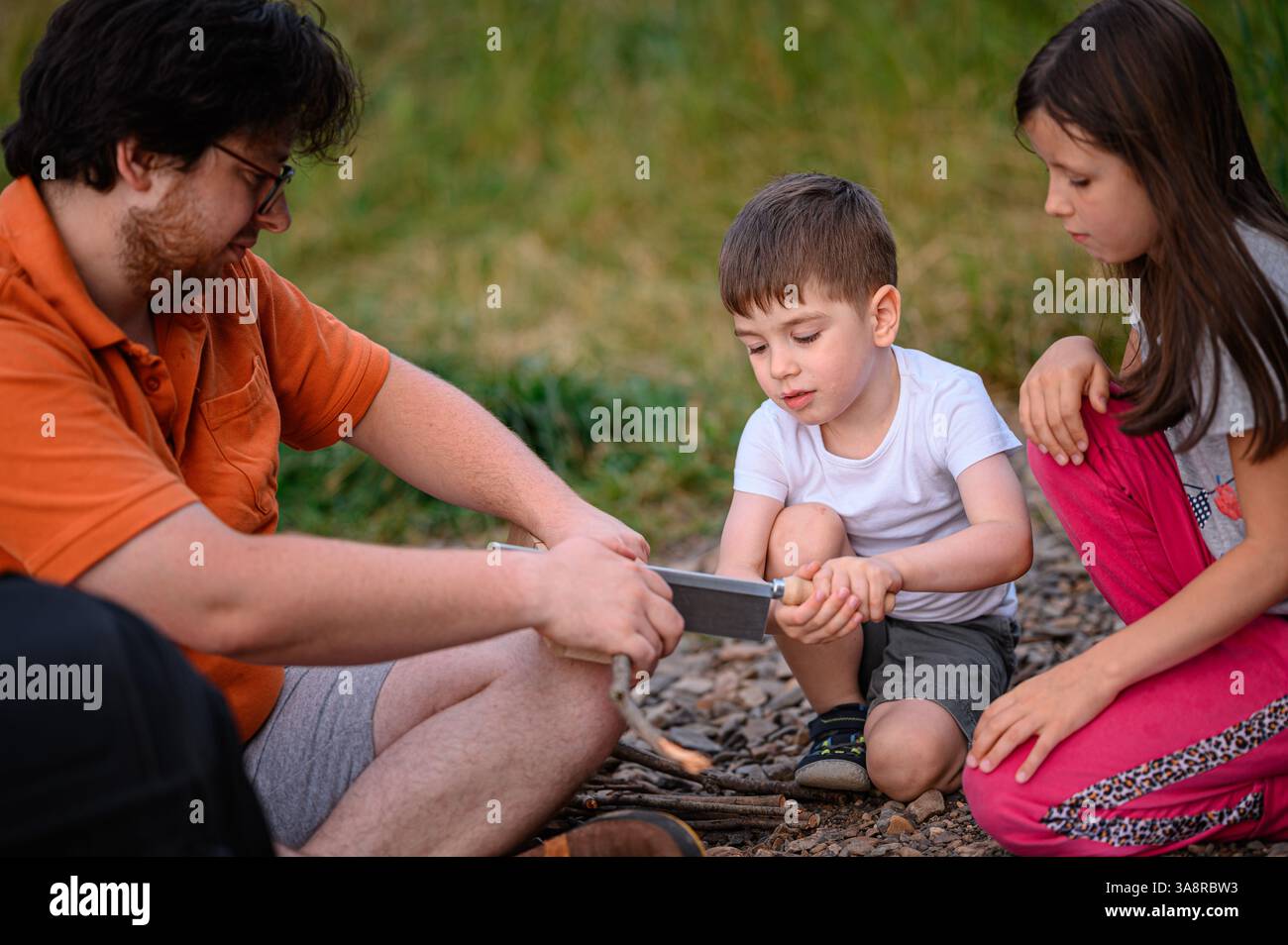 A father teaches his children how to saw wood, guiding them in a hands ...
