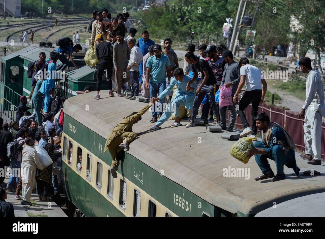 People board an overcrowded passenger train to reach their homes to ...