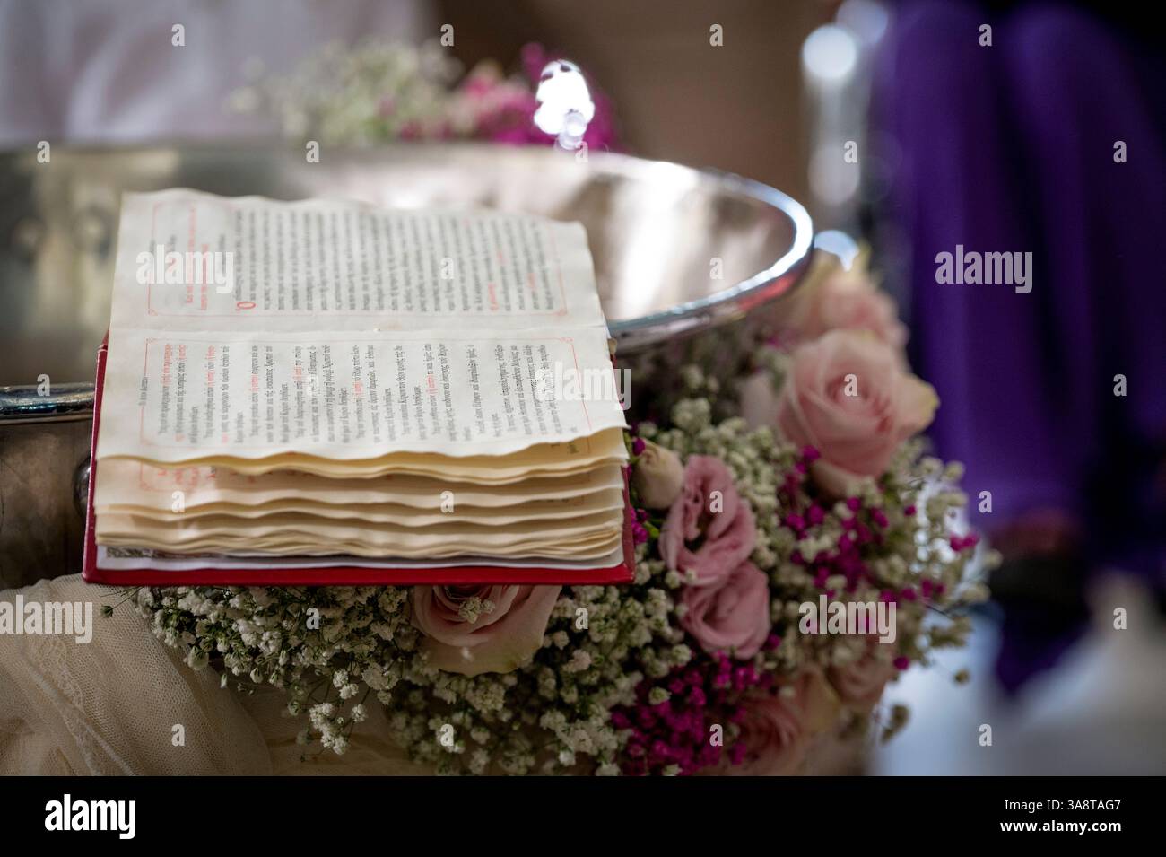 The holy bible open in front of the holy font, during a greek orthodox ...