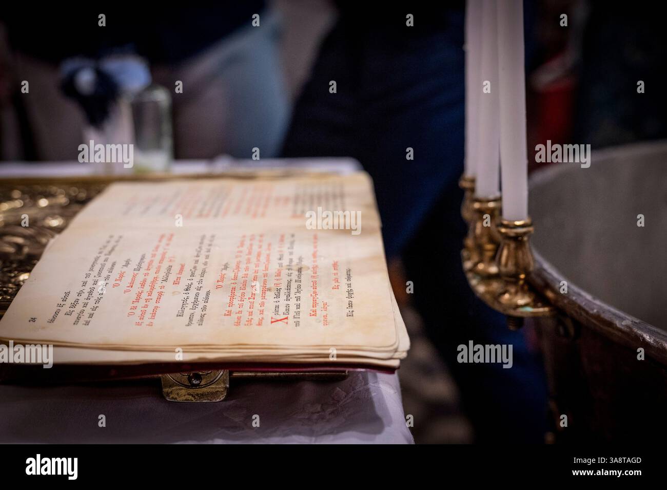 The holy bible open in front of the holy font, during a greek orthodox ...