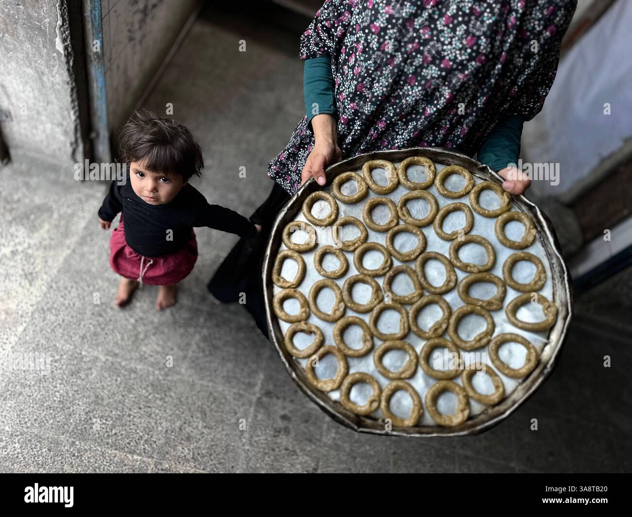 A Palestinian family prepares traditional cookies in preparation for ...