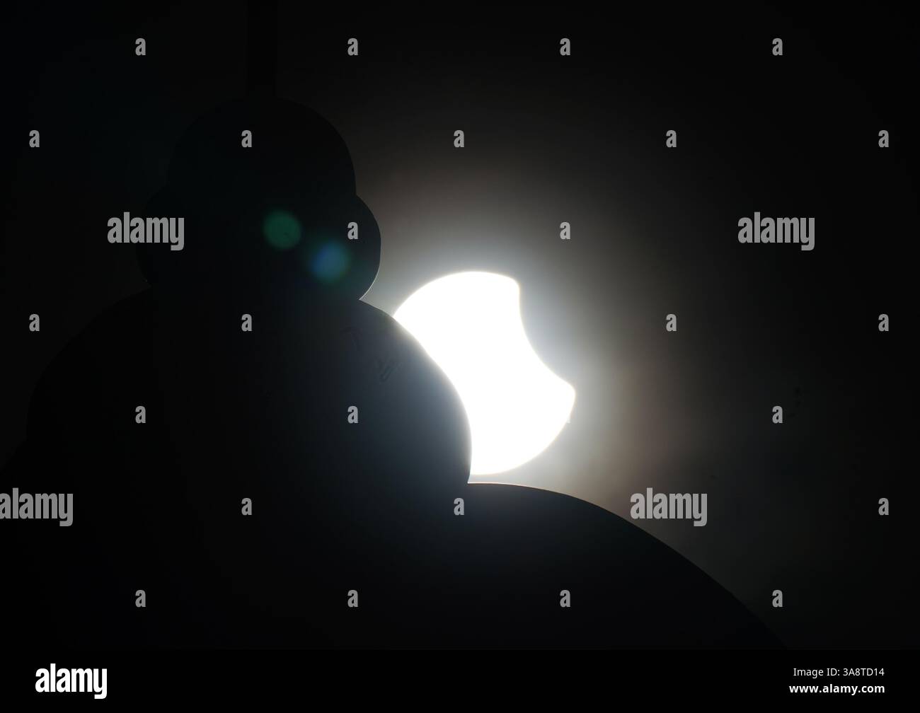 A partial solar eclipse is seen behind the domed roof of the Greenwich ...