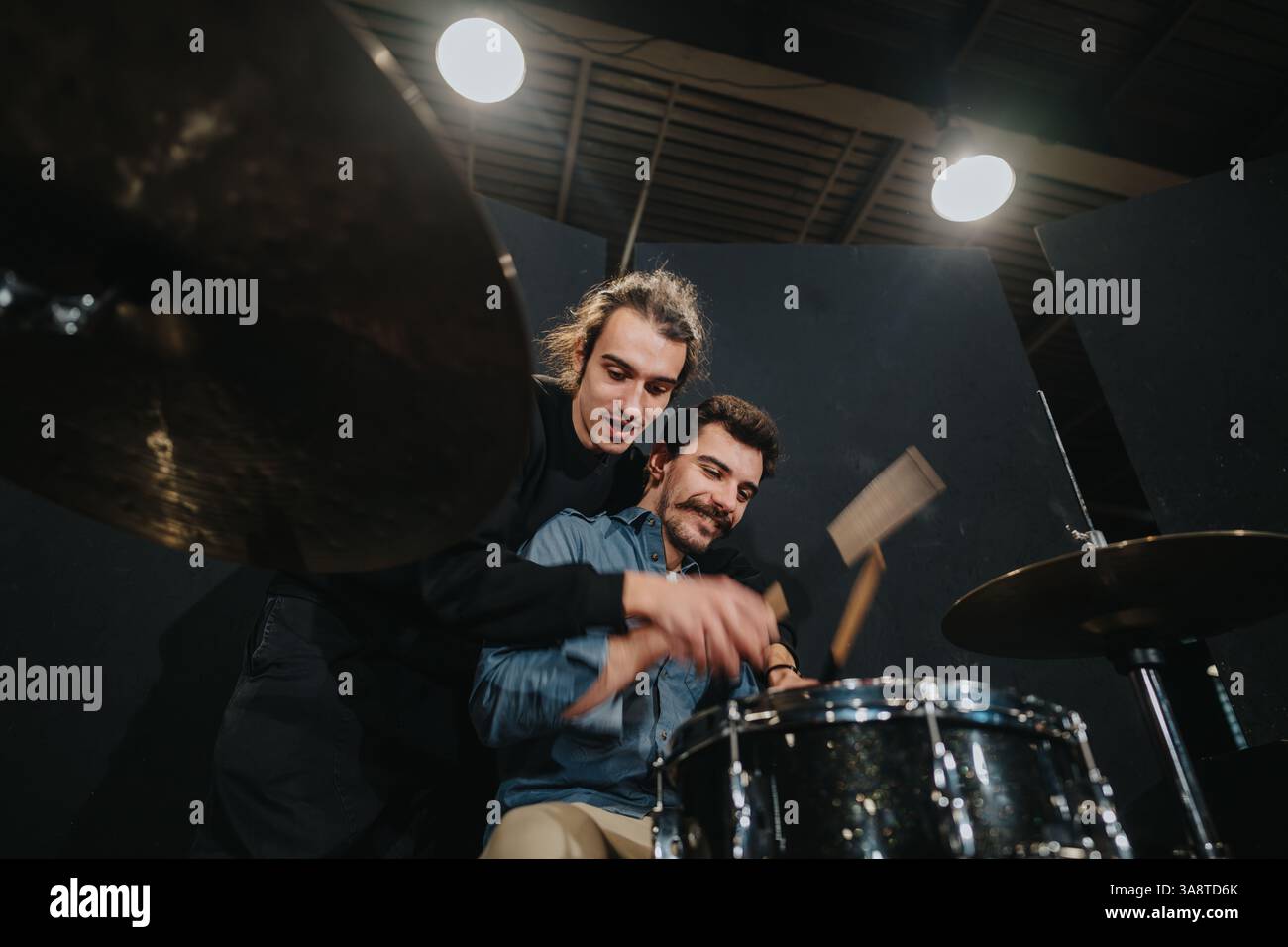 Two musicians collaborate during a band rehearsal session, focusing on ...
