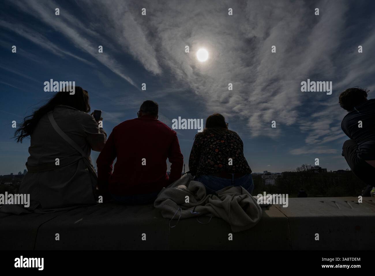 London, UK. 29 March 2025. UK Weather - People atop Primrose Hill watch ...
