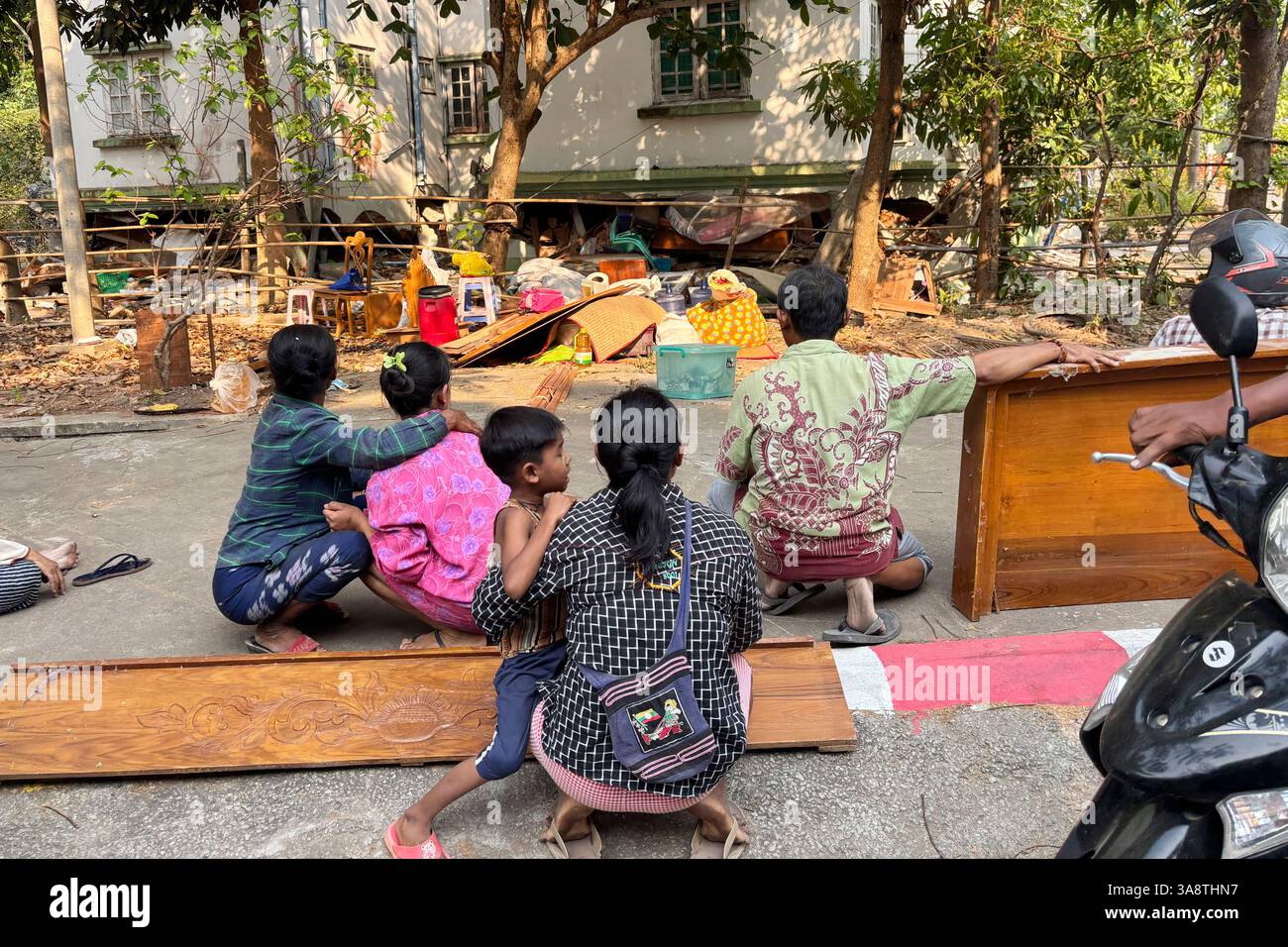 Peoples sit down on a platform near a damaged building after Friday's earthquake in Naypyitaw ...