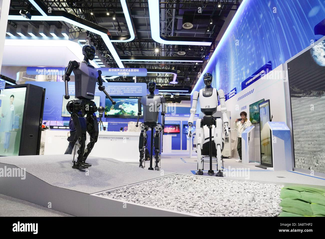 Beijing, China. 27th Mar, 2025. Humanoid robots walk during a permanent ...