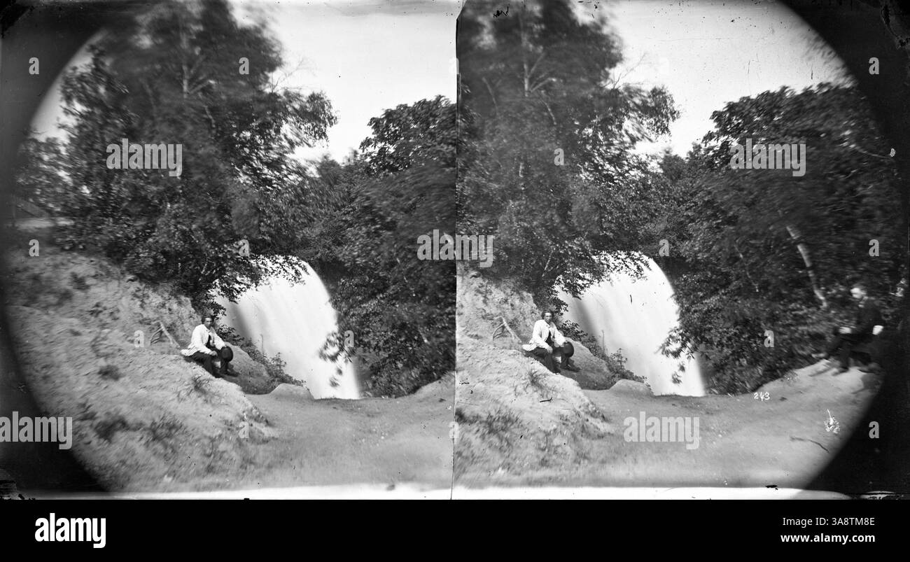 This image captures men standing close to the edge of Minnehaha Falls ...