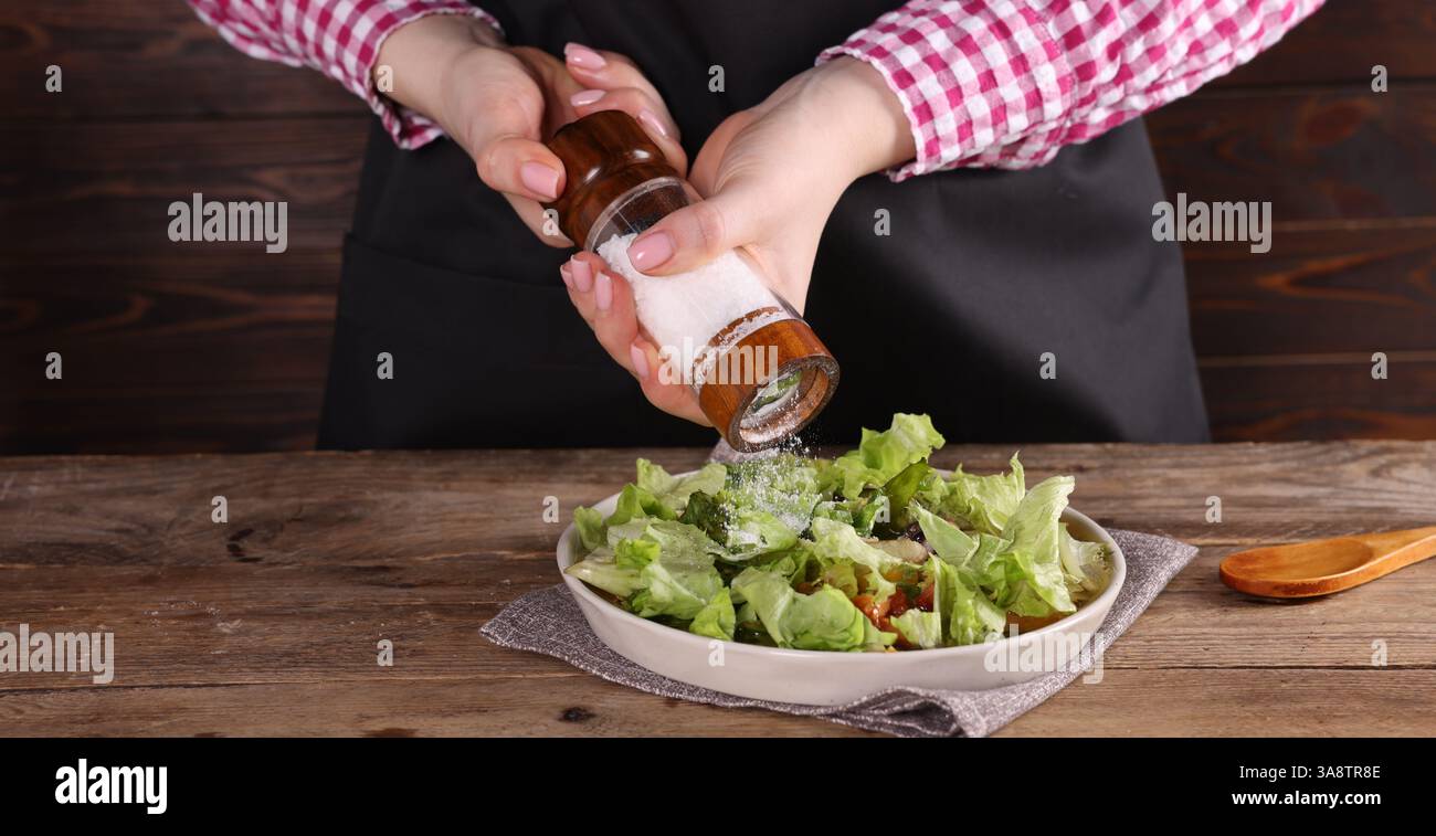 Woman salting tasty salad hi-res stock photography and images - Alamy