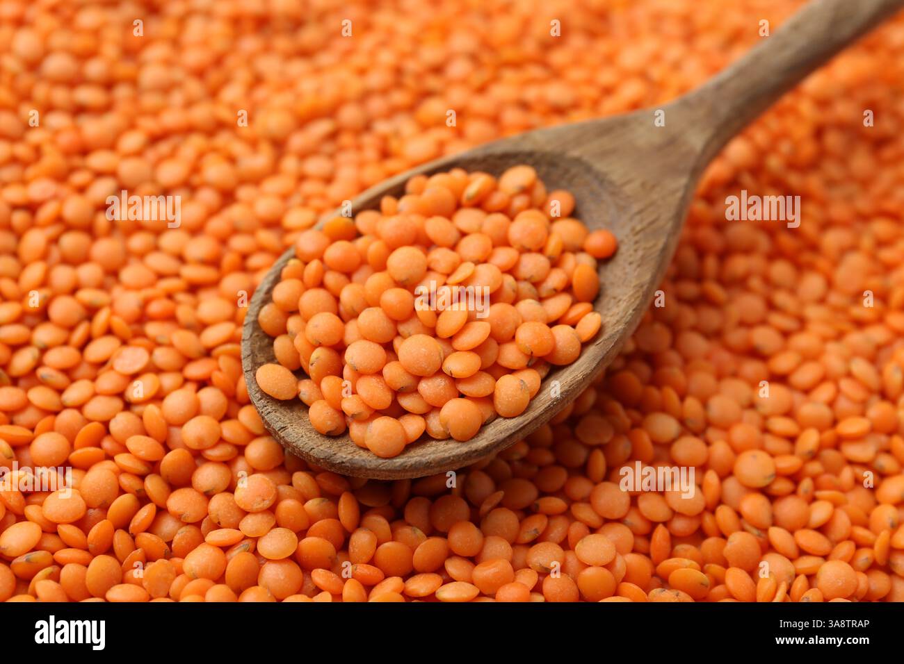 Raw red lentils and spoon as background, closeup view Stock Photo - Alamy