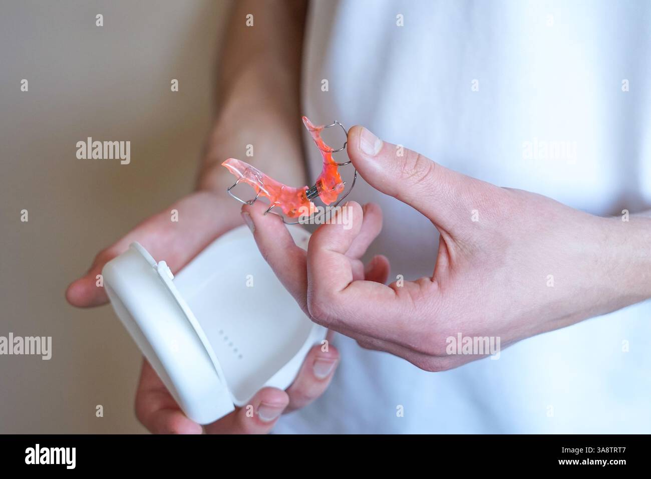 A close-up of a hand holding an orthodontic Palatal Expander , a device ...