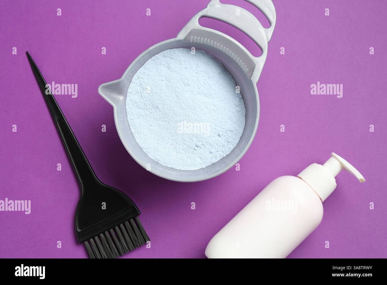 Bowl with hair bleaching powder, bottle of developer and brush on ...