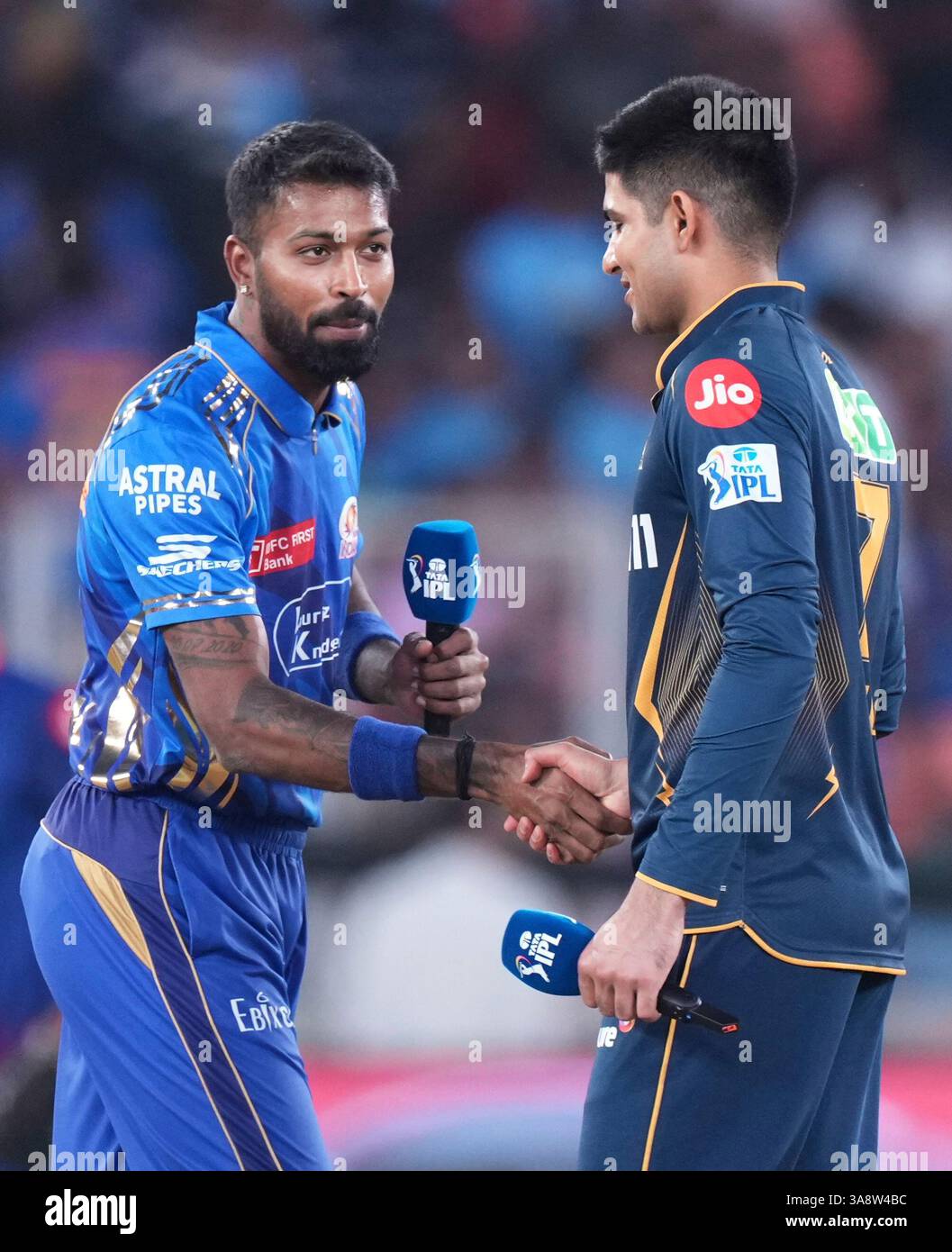 Gujarat Titans' captain Shubman Gill, right, and Mumbai Indians' captain Hardik Pandya shake ...
