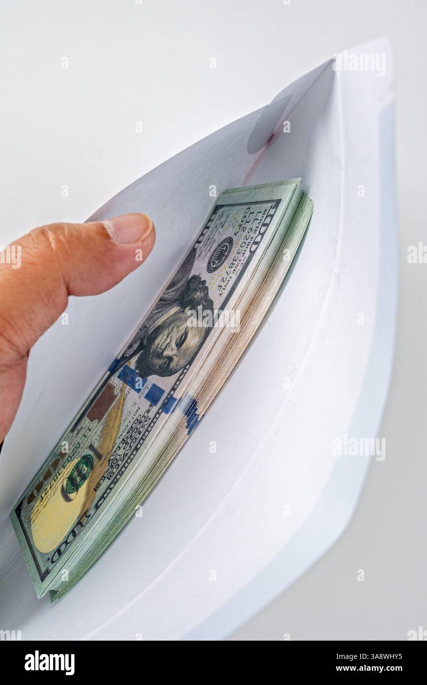 Money in the Envelope: A hand delicately unveils a stack of cash tucked ...