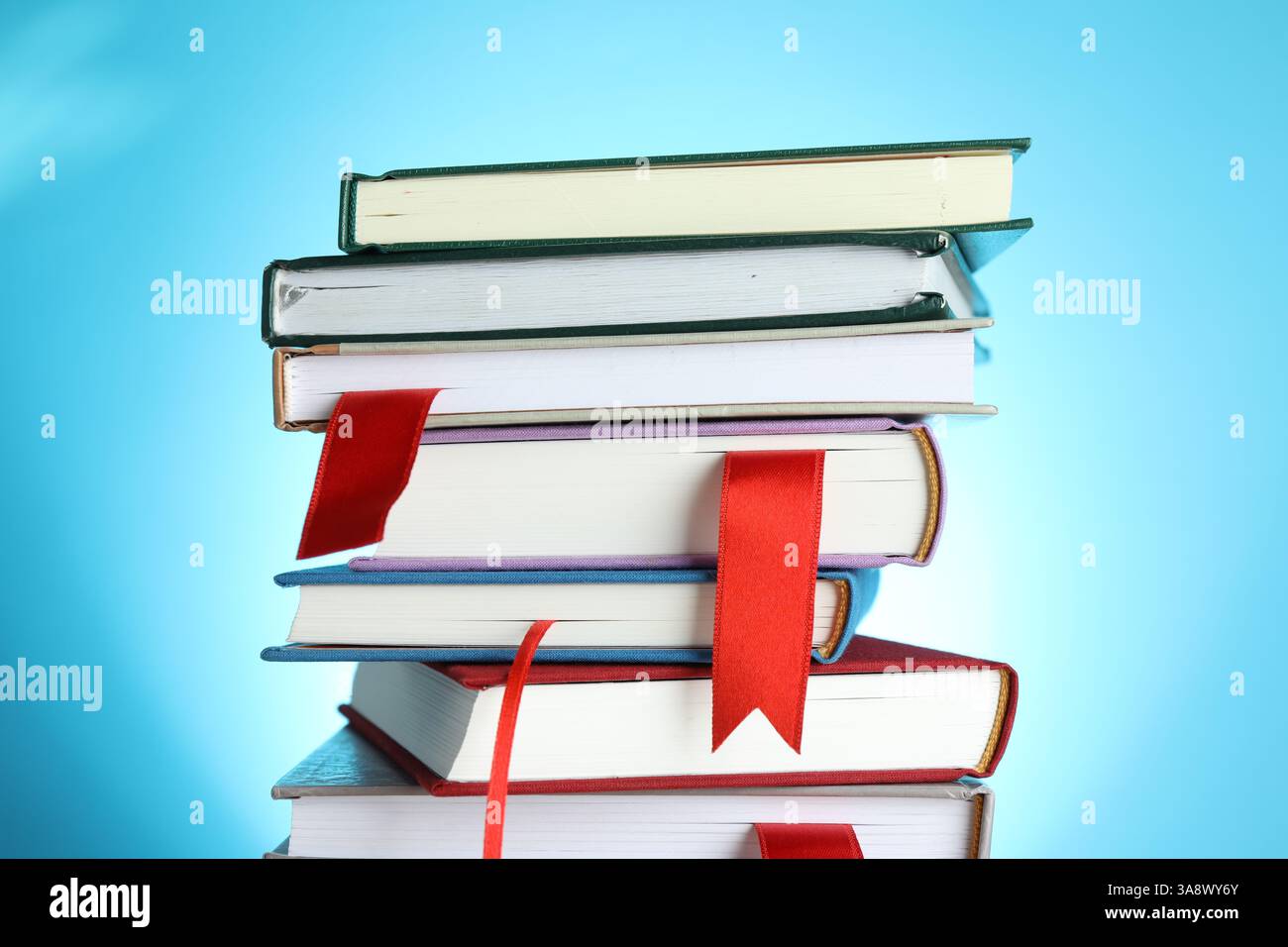 Books with red ribbon bookmarks on light blue background, closeup Stock ...