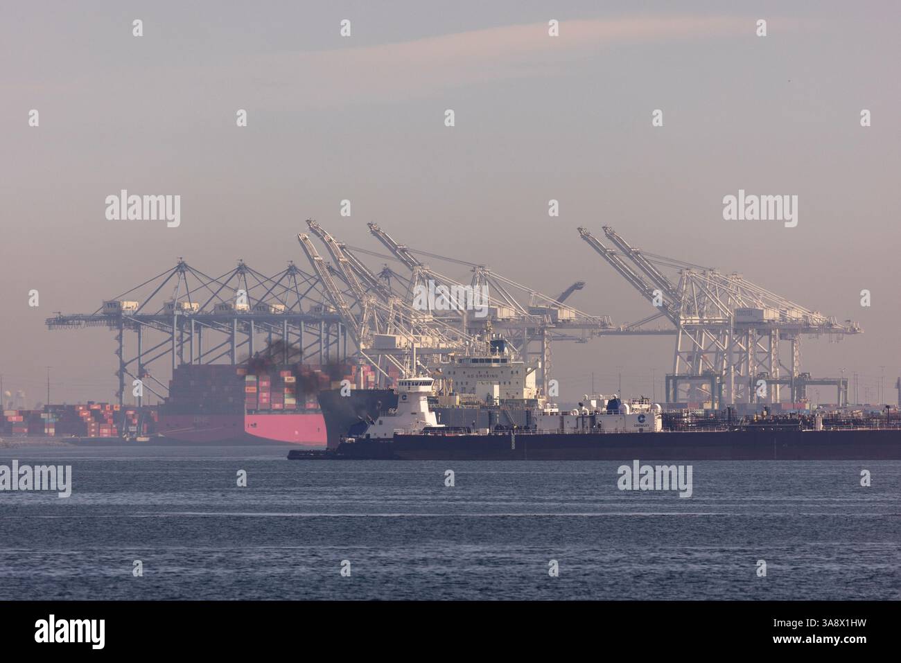 Pollution rises from a ship cruising by the port of Long Beach where ...