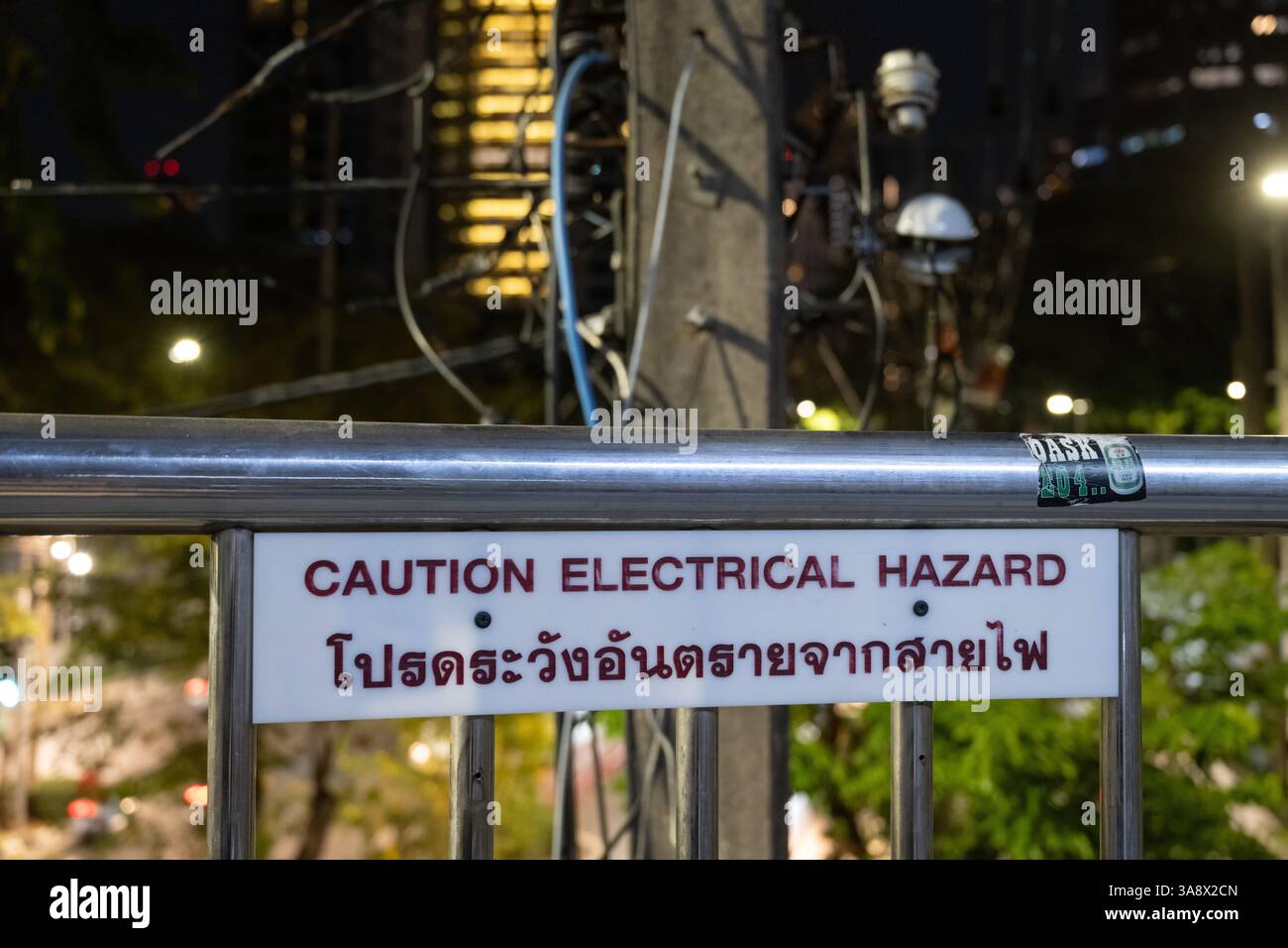 A caution against Electrical Hazard sign seen near an electricity pylon ...