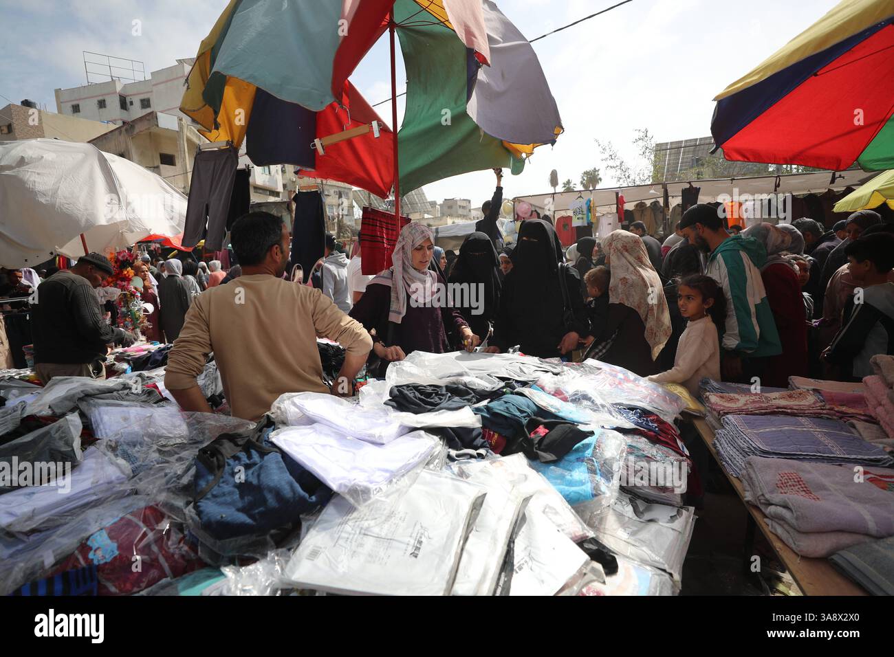 Palestinians shop at a local market in preparation for the upcoming Eid ...