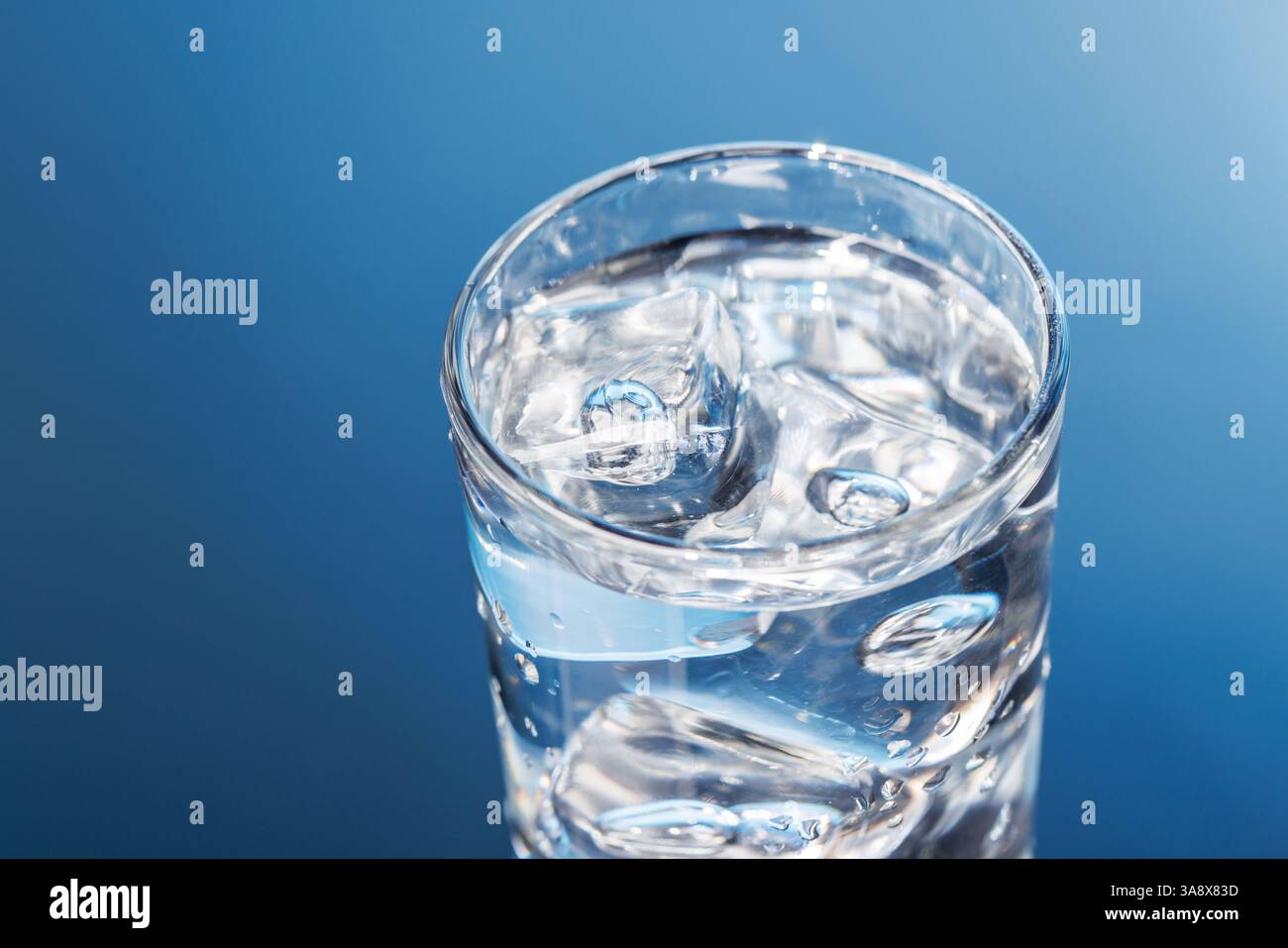 A clear glass filled with chilled water and ice cubes, creating a refreshing and cool drink. The ...