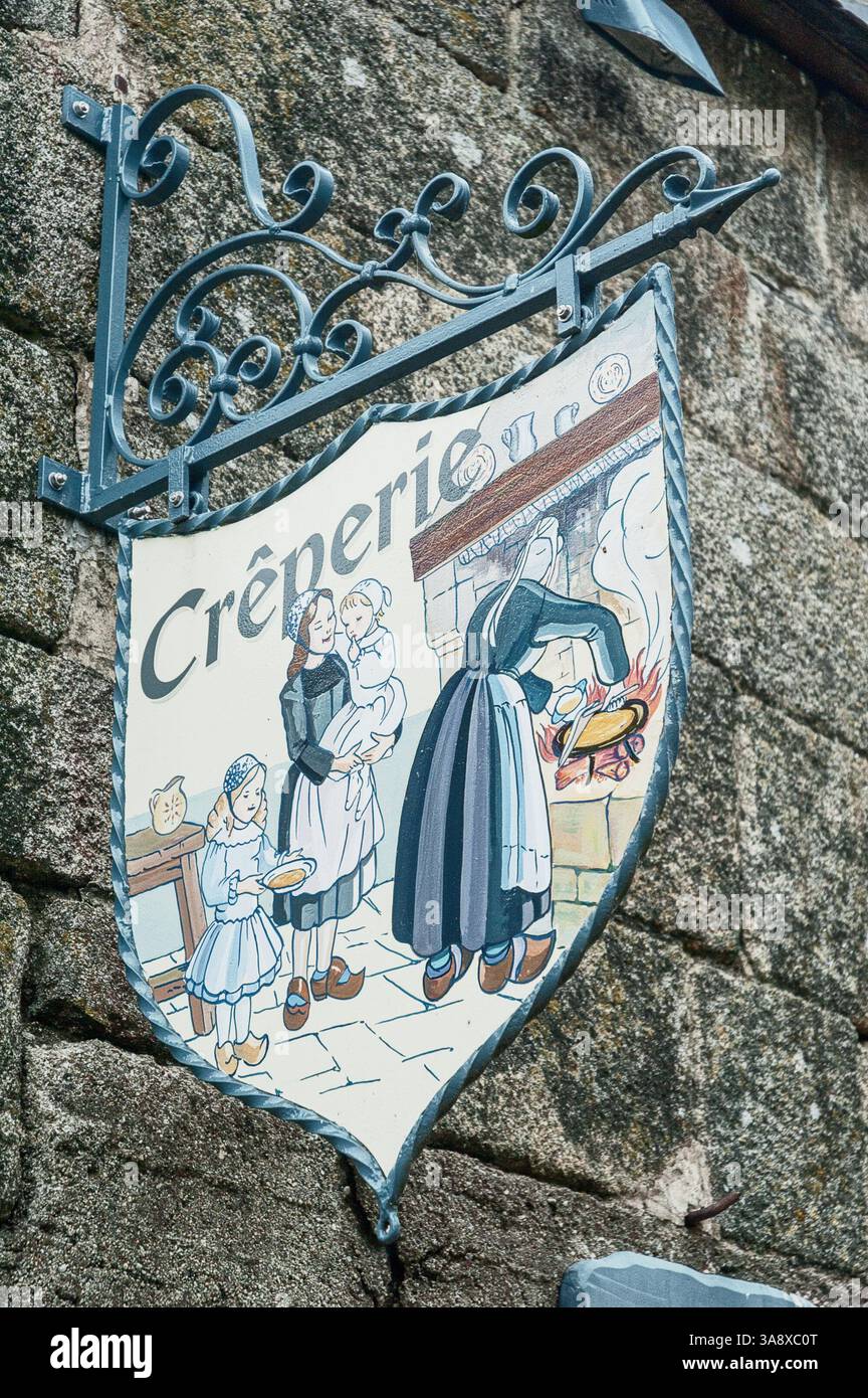 A creperie sign hangs from a wall mounted wrought iron bracket in ...