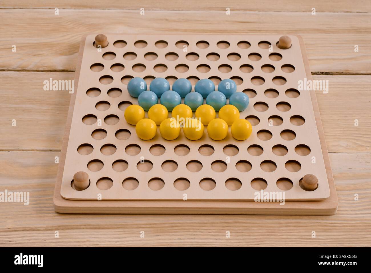 A wooden Montessori game with yellow-blue balls. The symbol of Ukraine ...