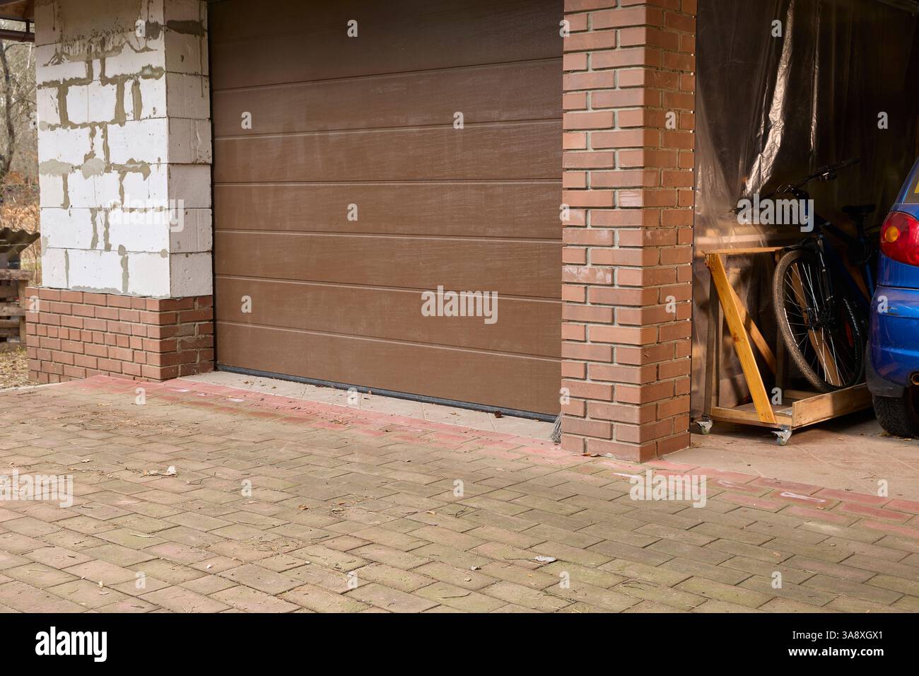 A closed garage door is positioned in a brick structure, concealing its ...