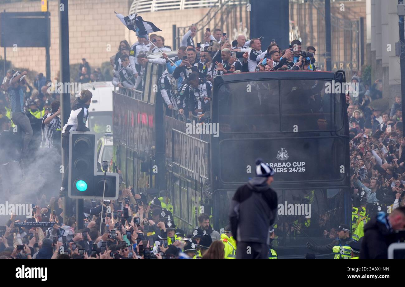 The open top buses carrying the Newcastle United players passes by fans ...