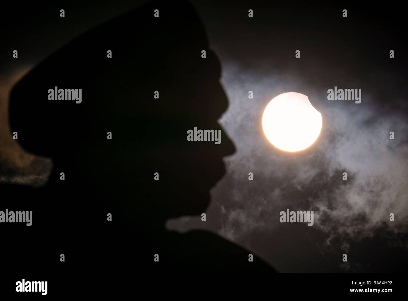 A view of a partial solar eclipse is seen behind the monument of the heroes of the First World ...