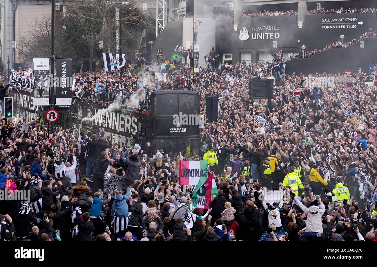 The open top buses carrying the Newcastle United players passes by fans ...