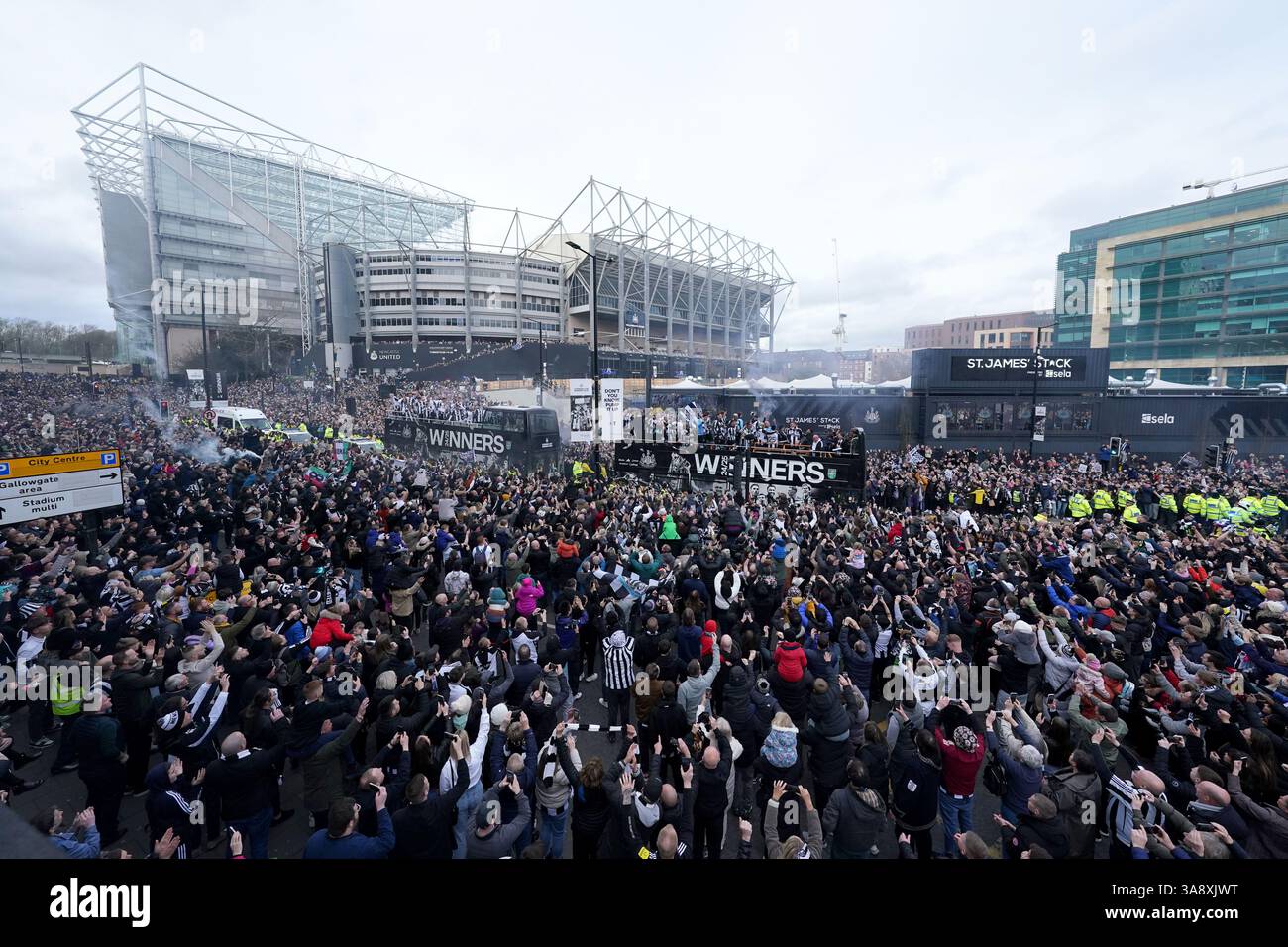 The open top buses carrying the Newcastle United players passes by fans ...