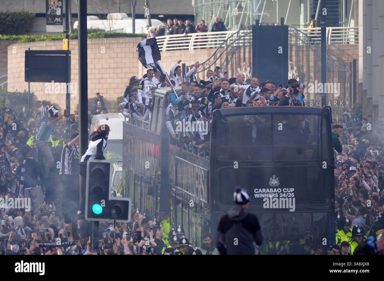 The open top buses carrying the Newcastle United players passes by fans ...