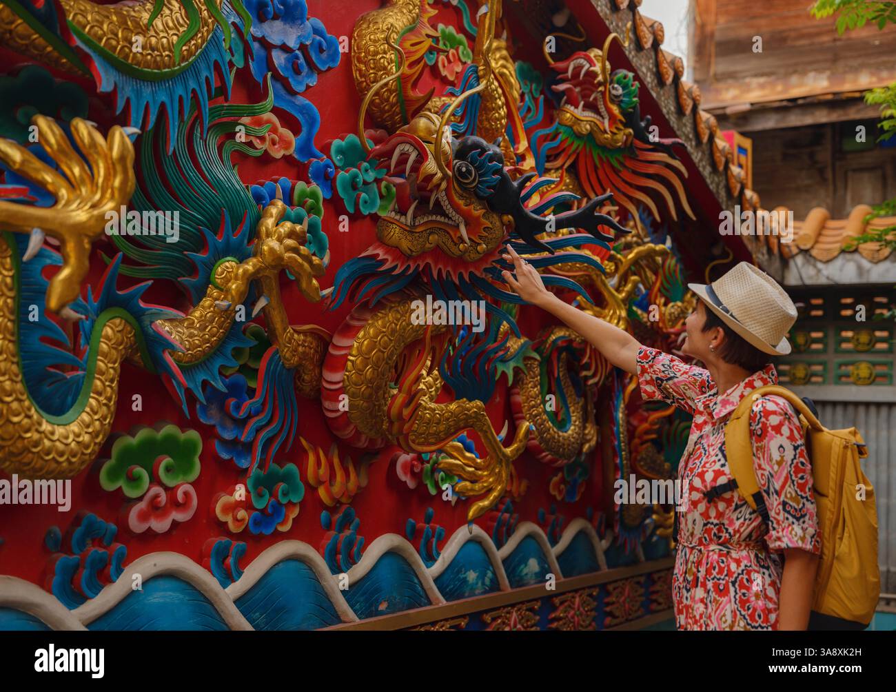 Female hand touches a colorful dragon sculpture on the grounds of a ...