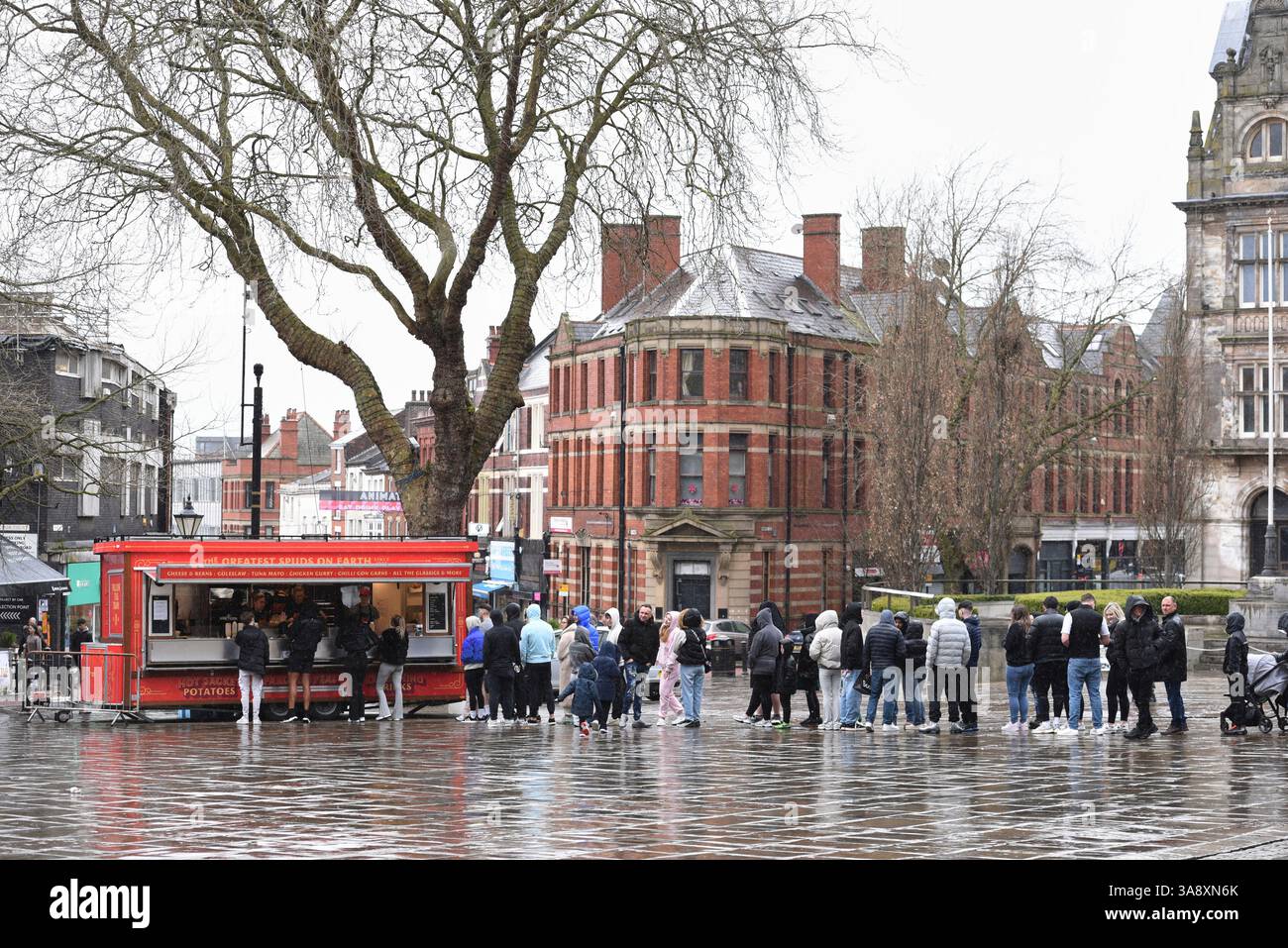 Preston, Lancashire, UK. 29th March 2025. People queing in the rain ...