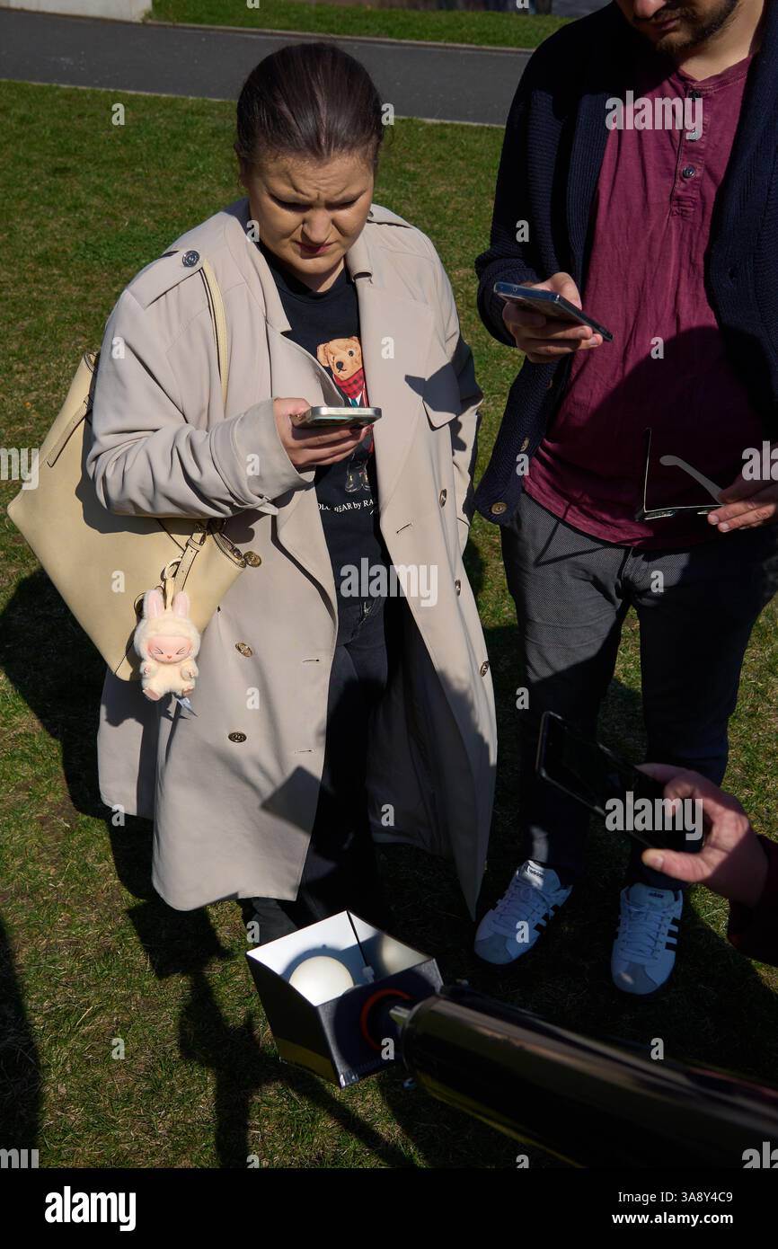 Visitors gather to watch the partial solar eclipse at the Copernicus ...