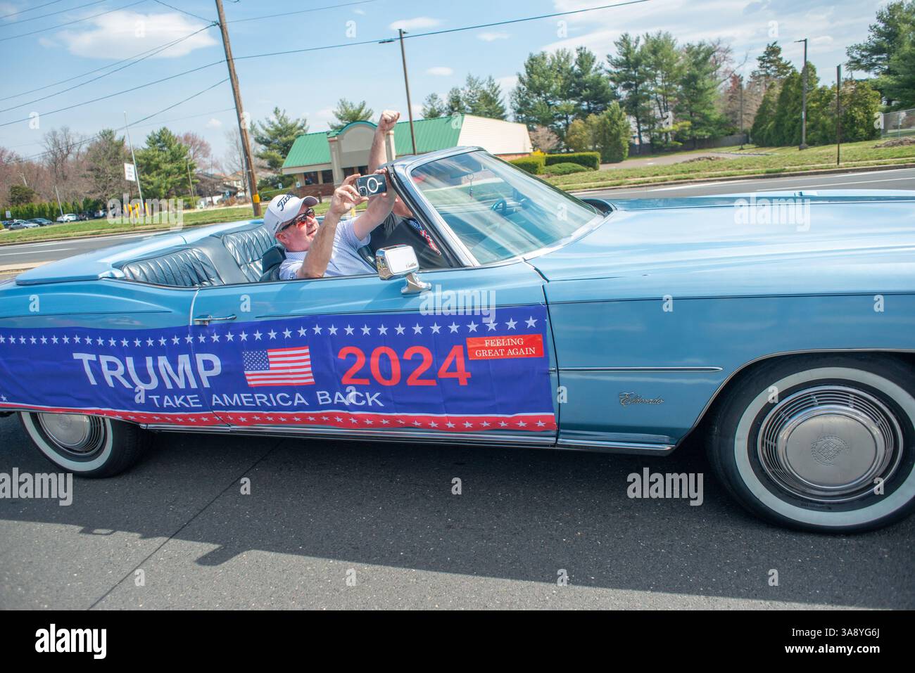 Warminster, Pennsylvania, USA. 29th Mar 2025. People wave flags during ...