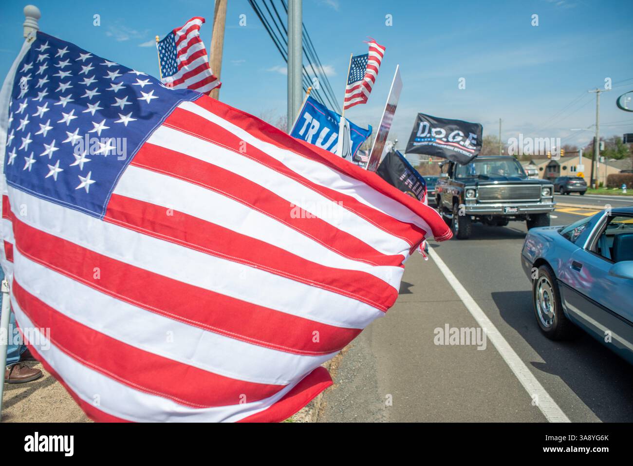 Warminster, Pennsylvania, USA. 29th Mar 2025. People wave flags during ...