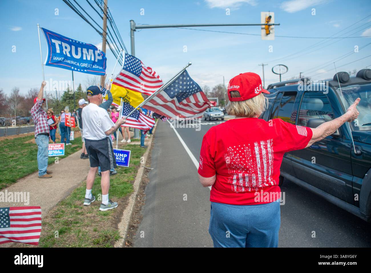 Warminster, Pennsylvania, USA. 29th Mar 2025. People wave flags during ...