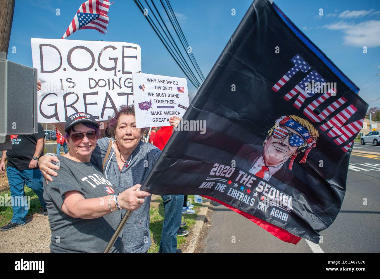 Warminster, Pennsylvania, USA. 29th Mar 2025. People wave flags during ...