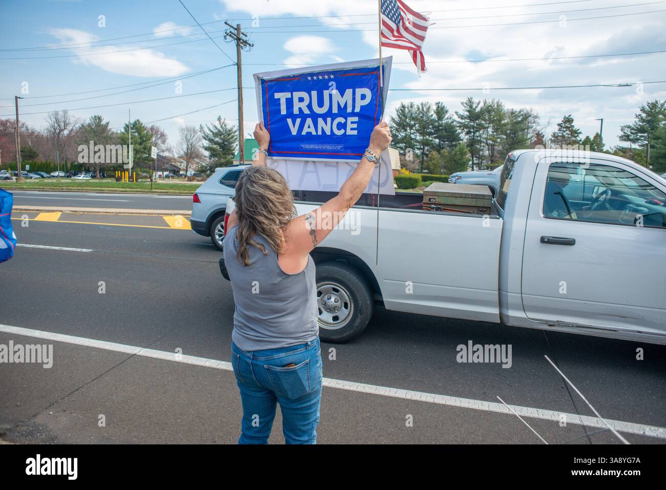 Warminster, Pennsylvania, USA. 29th Mar 2025. People wave flags during ...