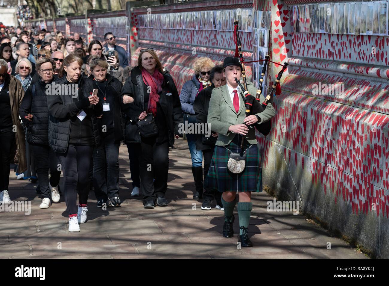 London, UK. 29 March, 2025. Bagpiper Iona Scotson leads a procession of ...