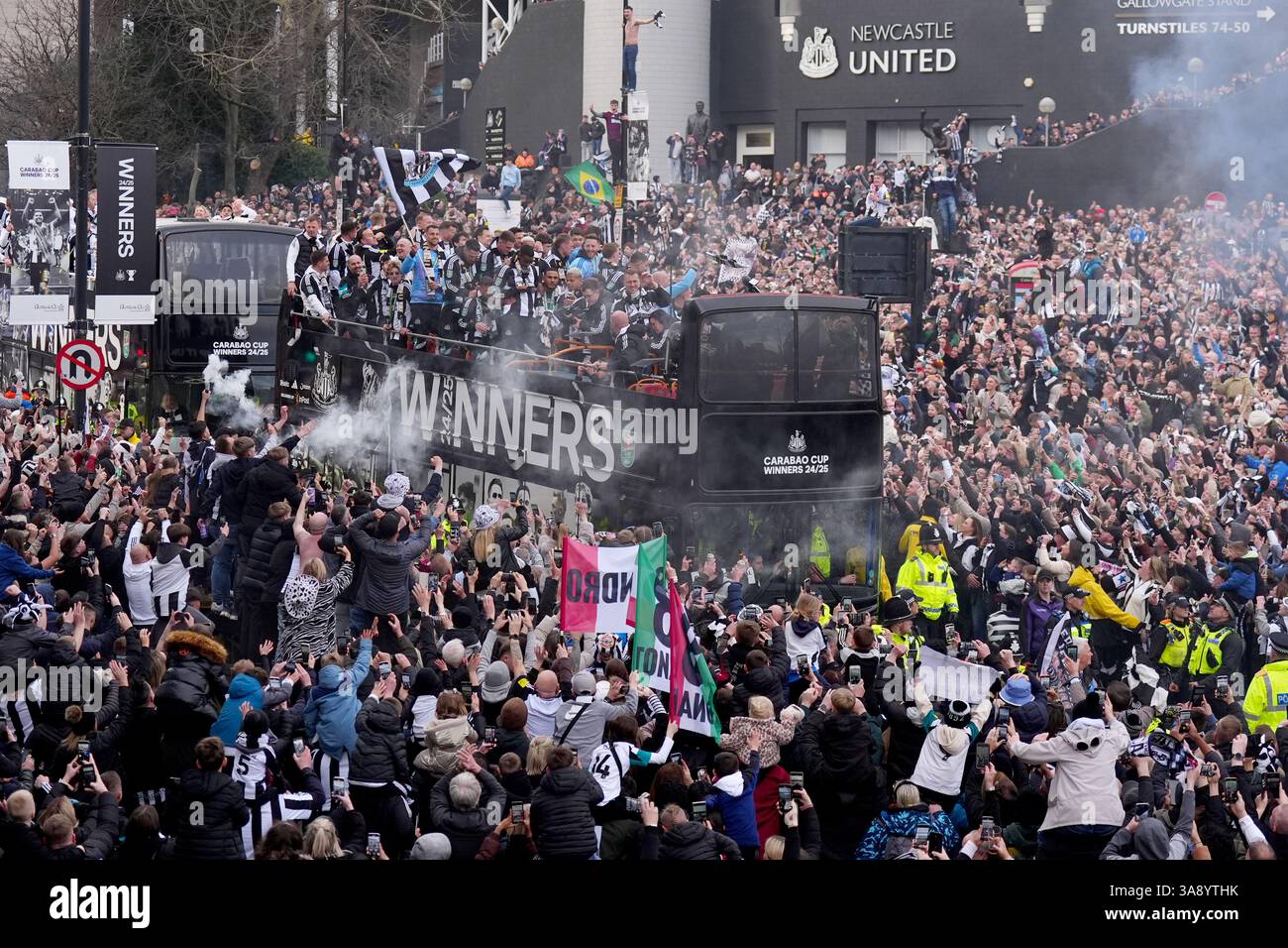 The open top buses carrying the Newcastle United players passes by fans ...