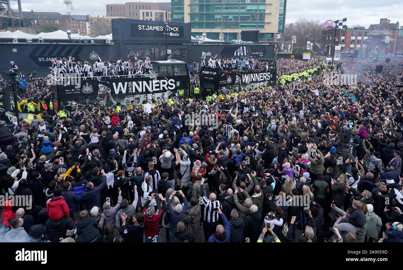 The open top buses carrying the Newcastle United players passes by fans ...