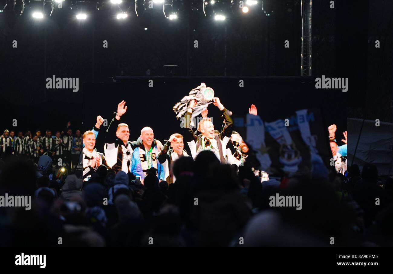 A big screen shows Newcastle United's Dan Burn lifts the trophy in ...