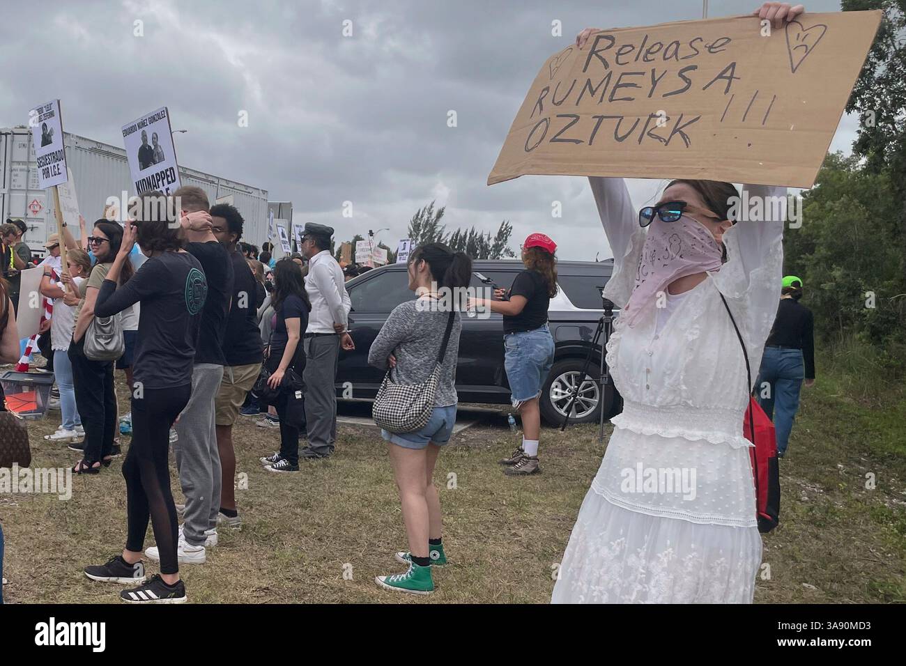 People hold up signs during a protest outside Krome Detention Center in ...