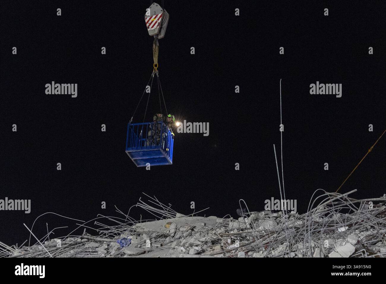 Rescuers work at the site of a collapsed under construction high-rise ...
