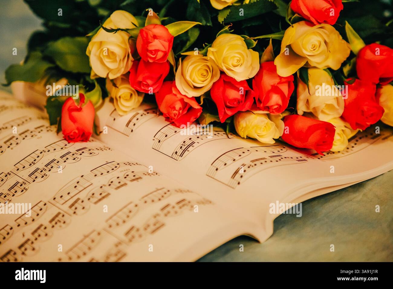 A book with a bunch of roses on top of it. The roses are pink and white ...