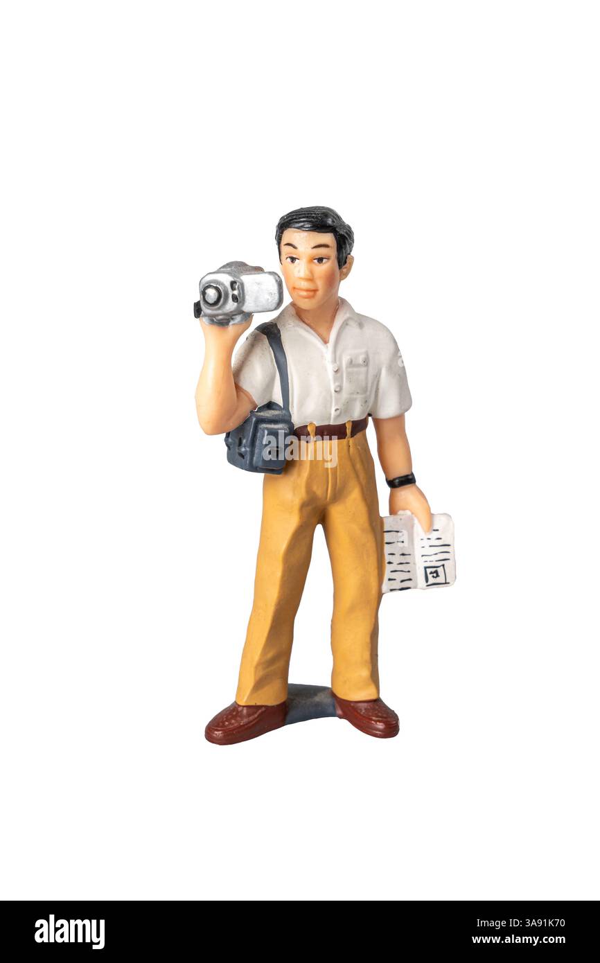 A man is holding a camera and a newspaper. He is wearing a white shirt ...