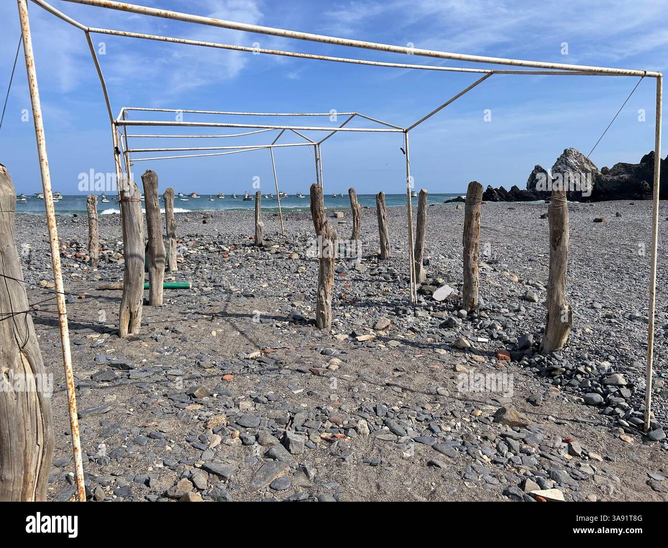 Rustic Beach Scene with Wooden Structure, Pebbles, and Boats at Yacila ...