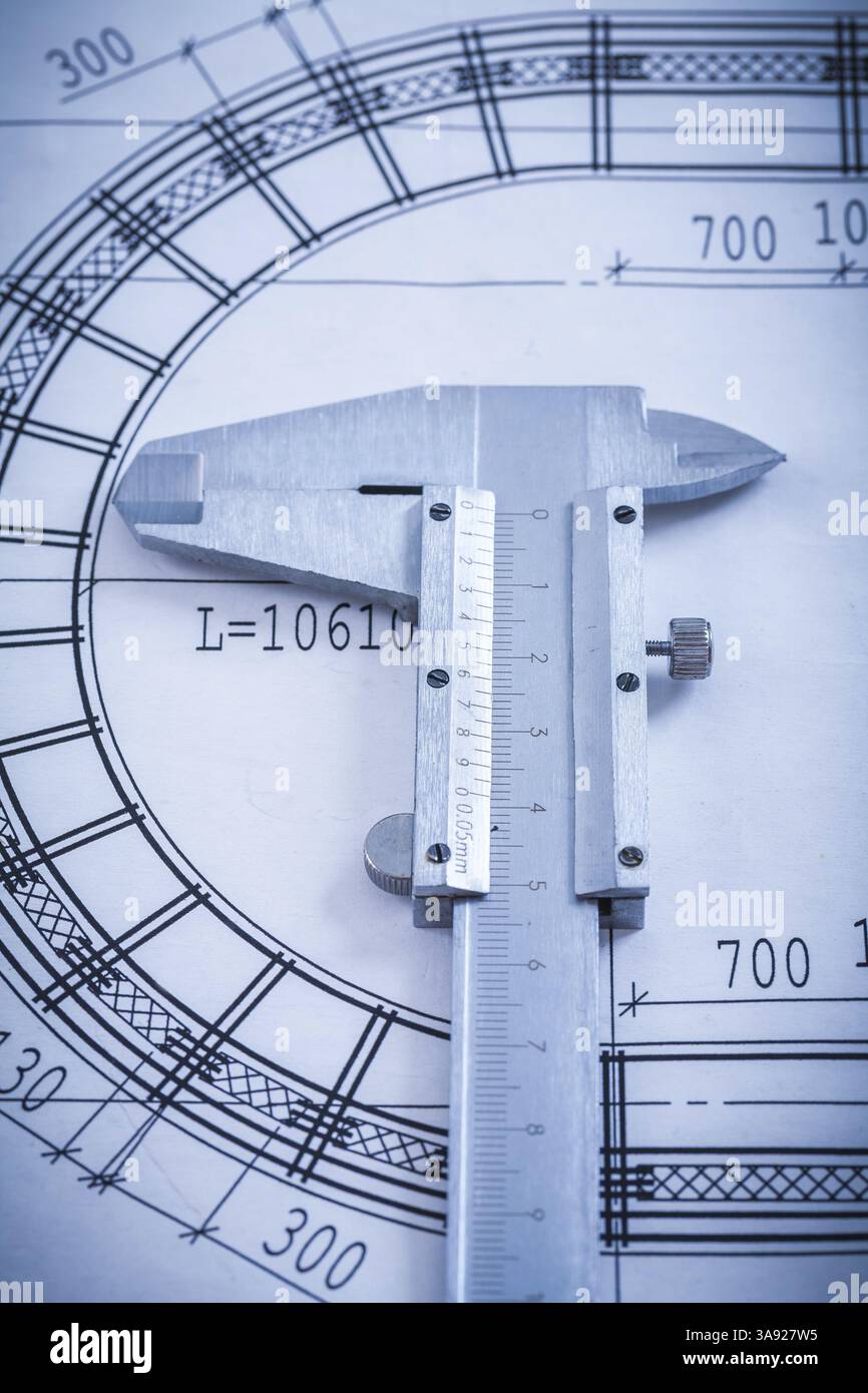 Stainless slide caliper on blueprint vertical view construction concept ...