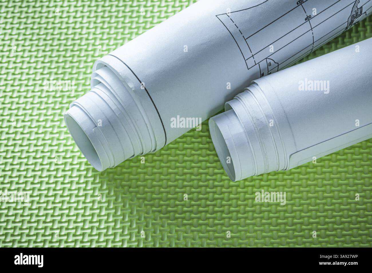 Rolled construction drawings on green background building concept Stock ...