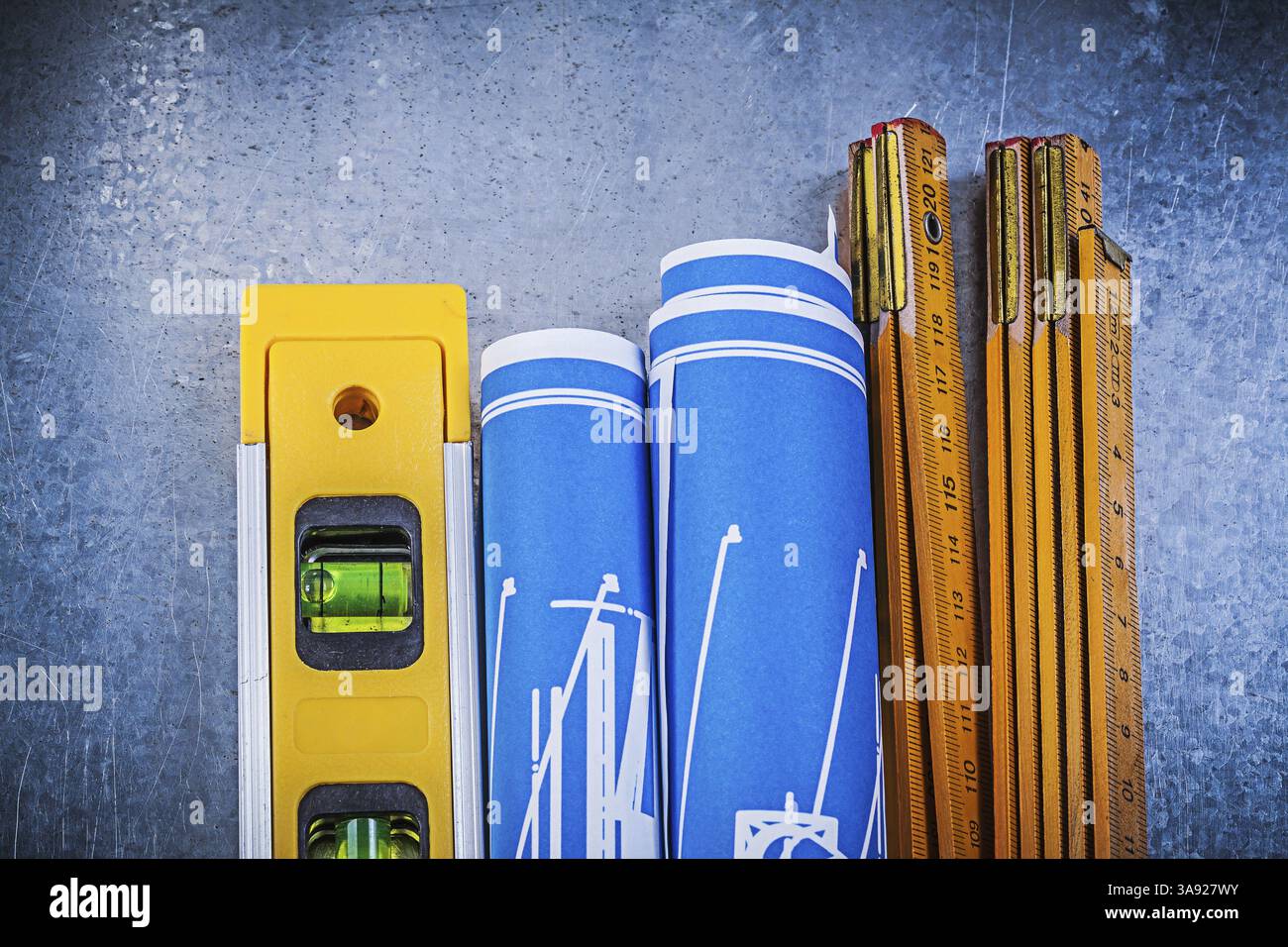 Wooden meter blue construction drawings level on metallic background ...